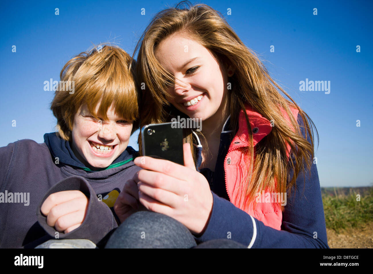Two teenagers looking at iphone Stock Photo - Alamy