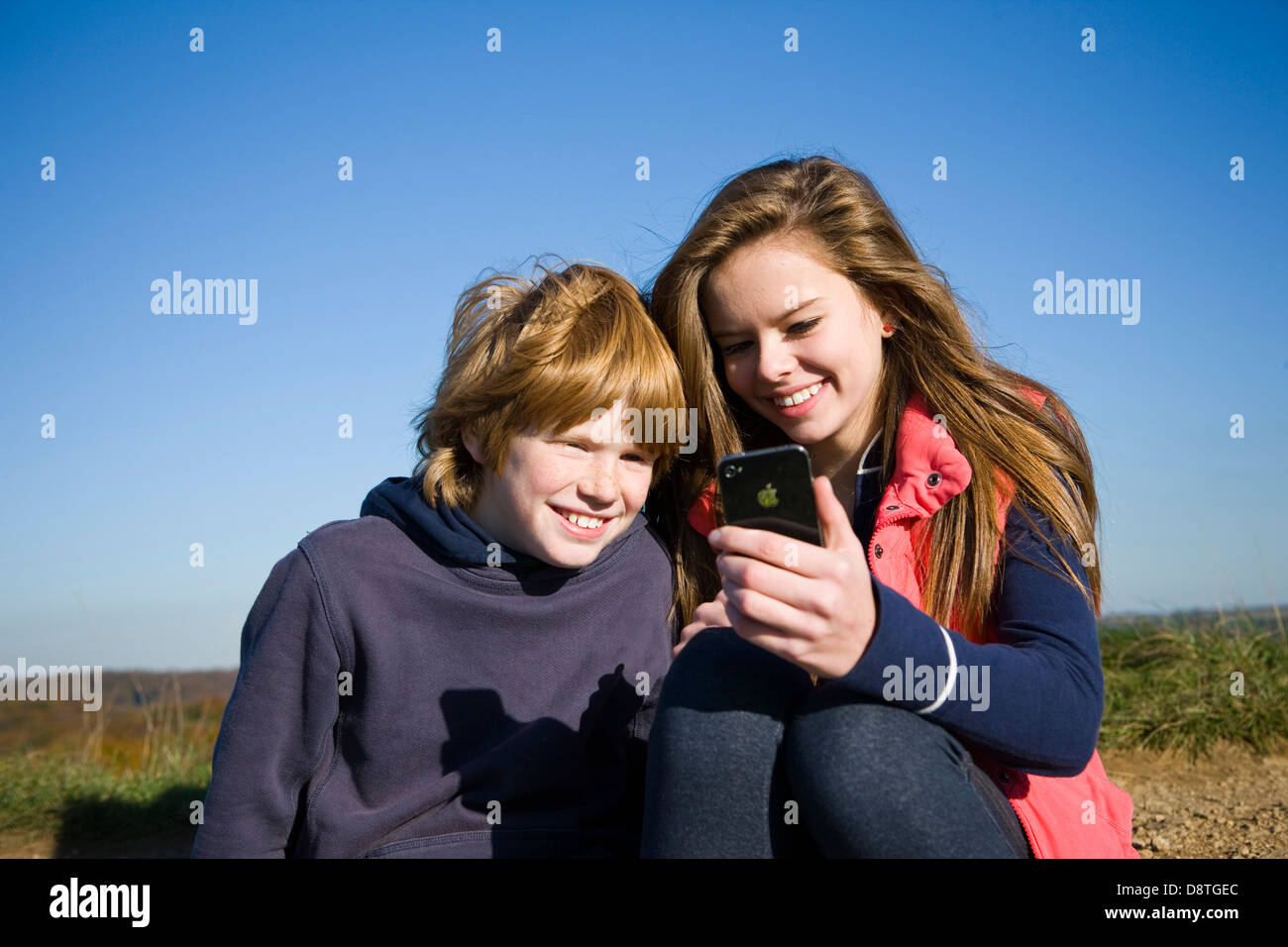Two teenagers looking at iphone Stock Photo - Alamy