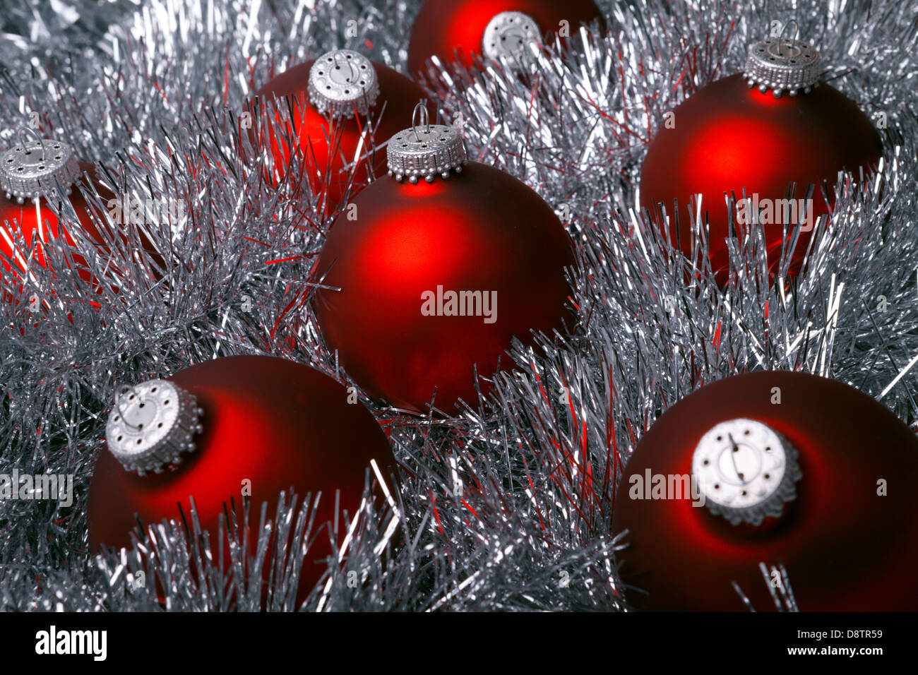 red christmas baubles on the silver tinsel Stock Photo - Alamy