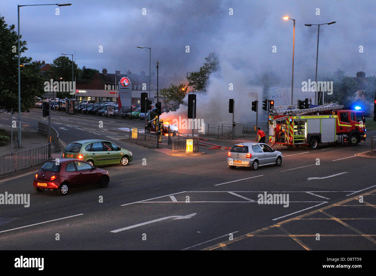 Car on fire accident at cross road, traffic light smoke, fire brigade ...