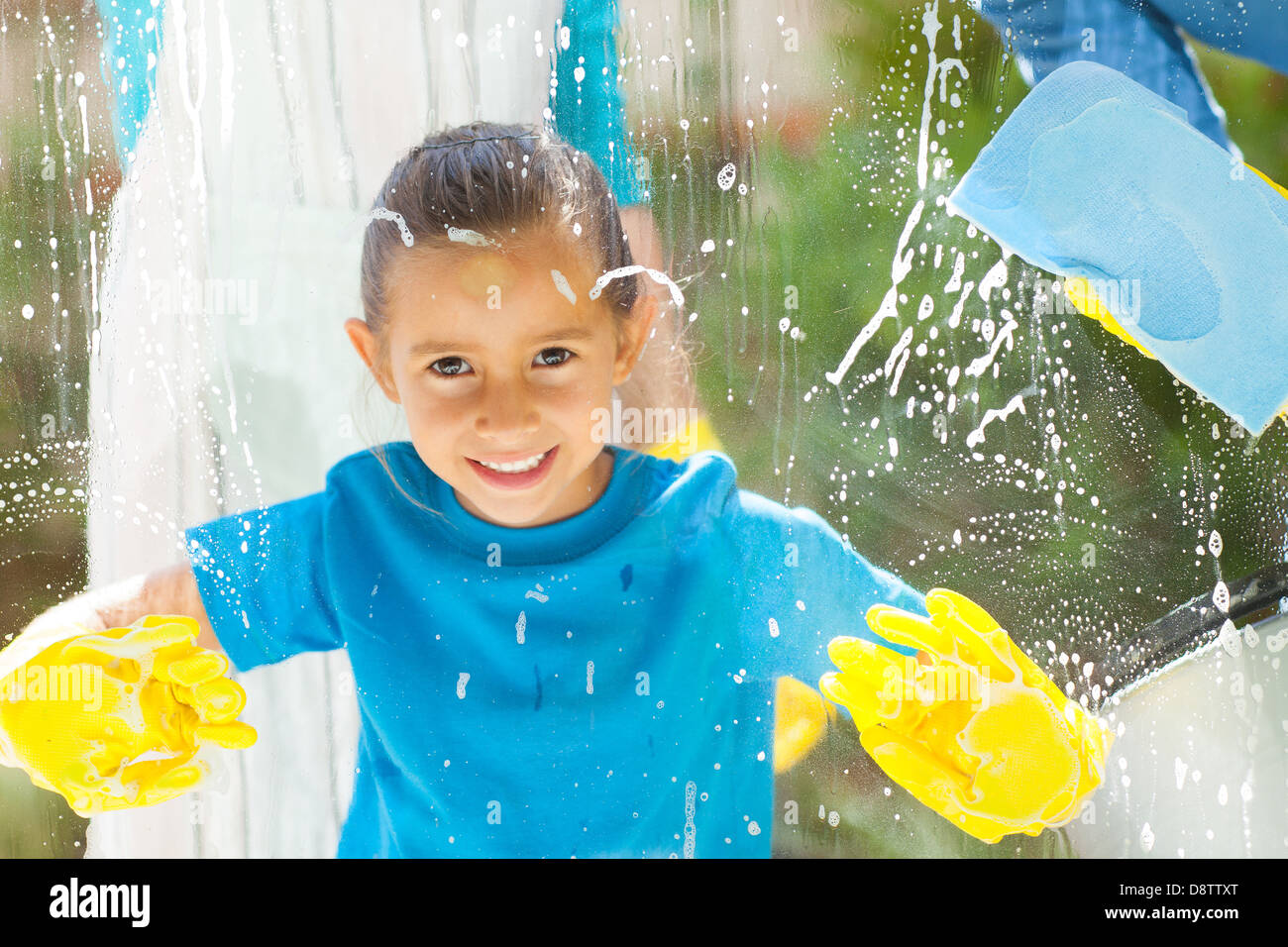 cute little girl cleaning window glass with parents at home Stock Photo ...