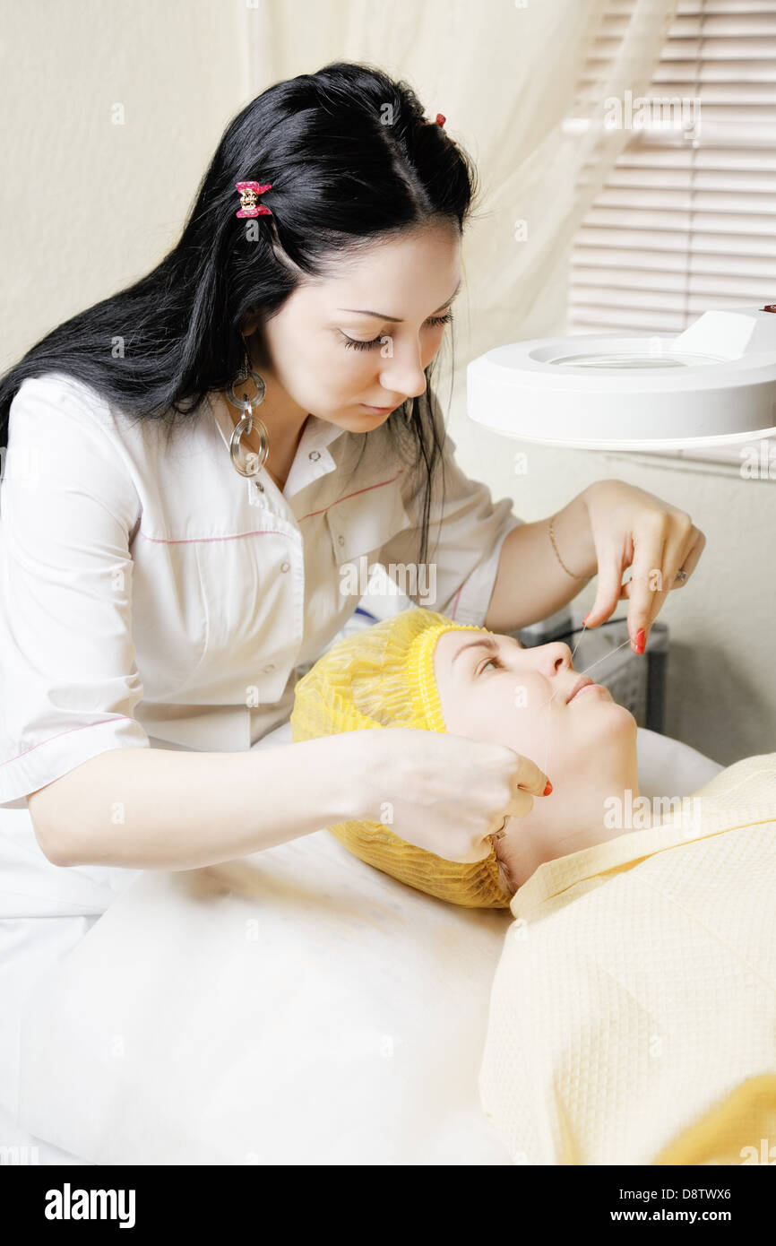 Woman threading hi-res stock photography and images - Alamy