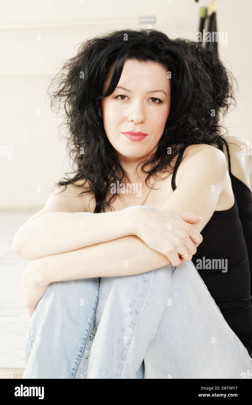 Brunette sitting against mirror Stock Photo - Alamy