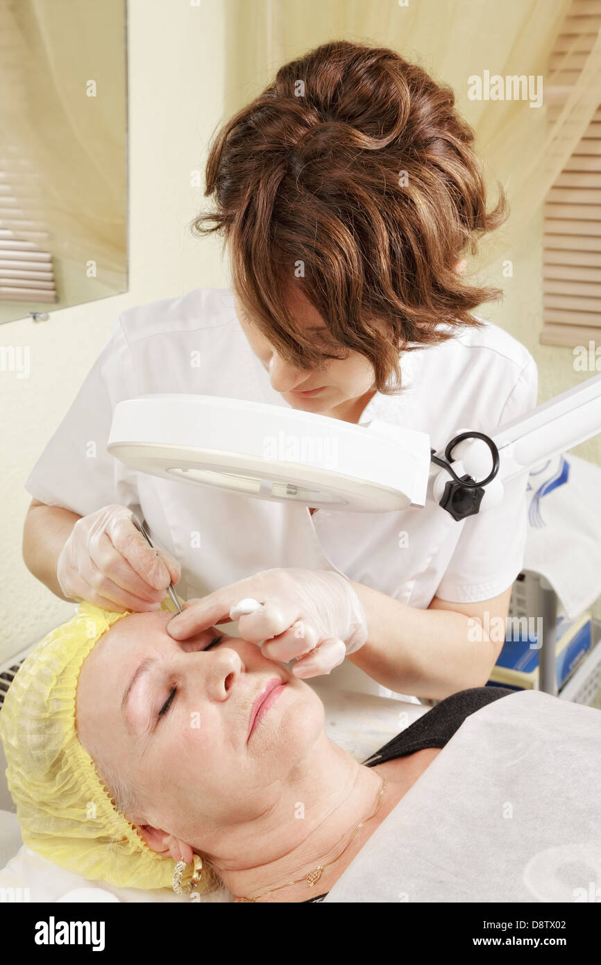 Beautician at eyebrows tweezing procedure Stock Photo - Alamy