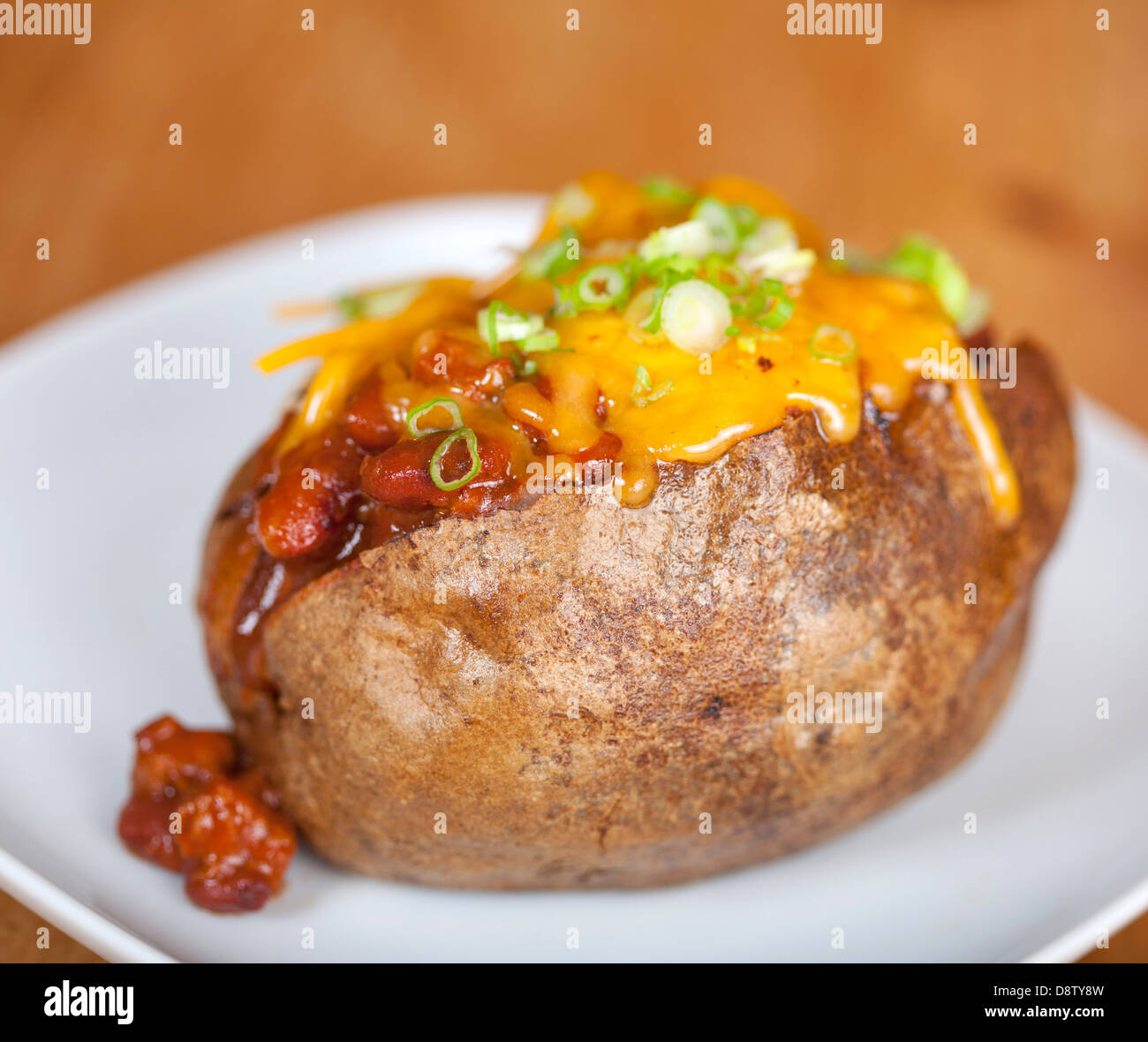 Loaded baked potato with chili and cheese on a plate Stock Photo - Alamy