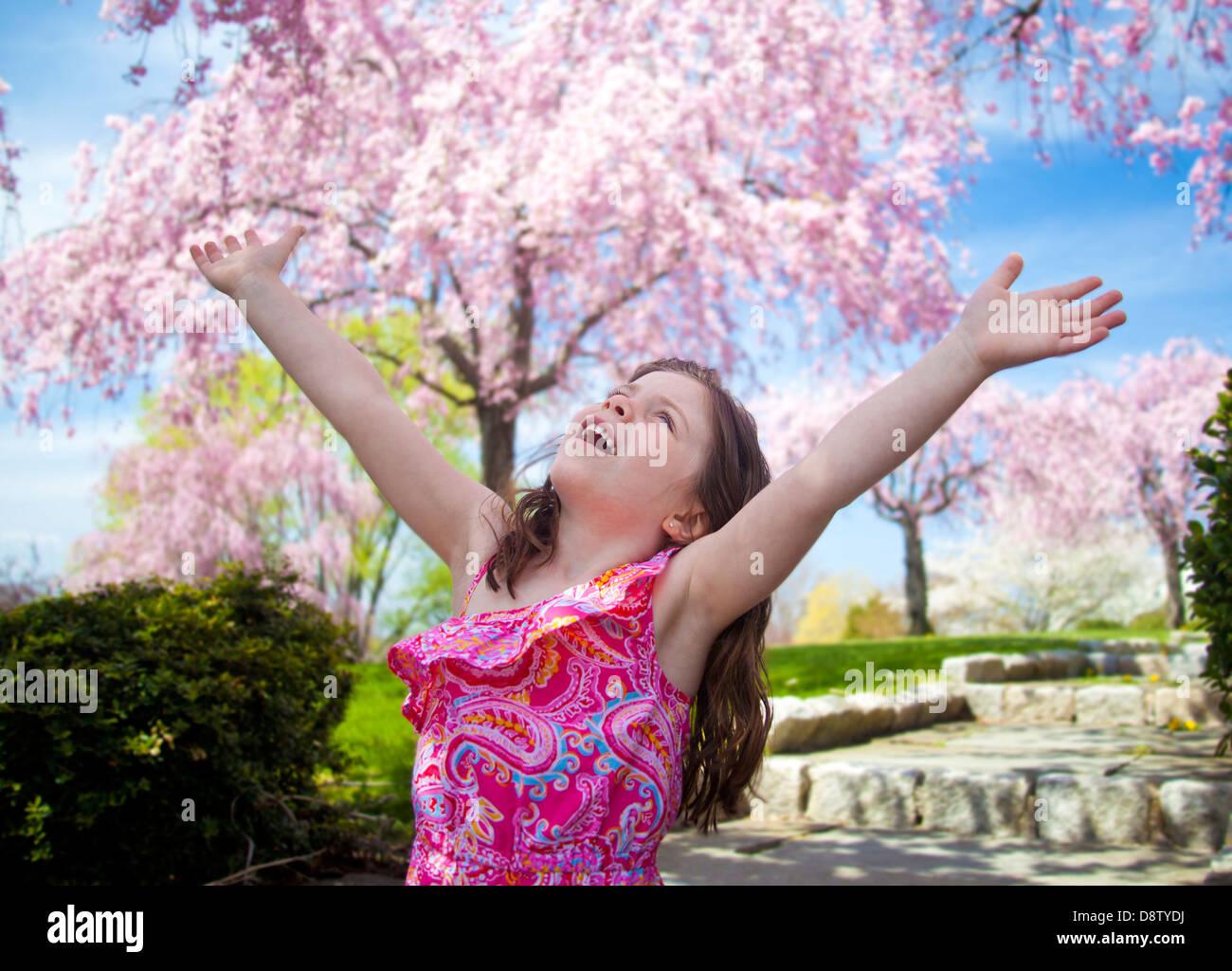 Young girl taking a deep breath enjoying freedom with arms in the air ...