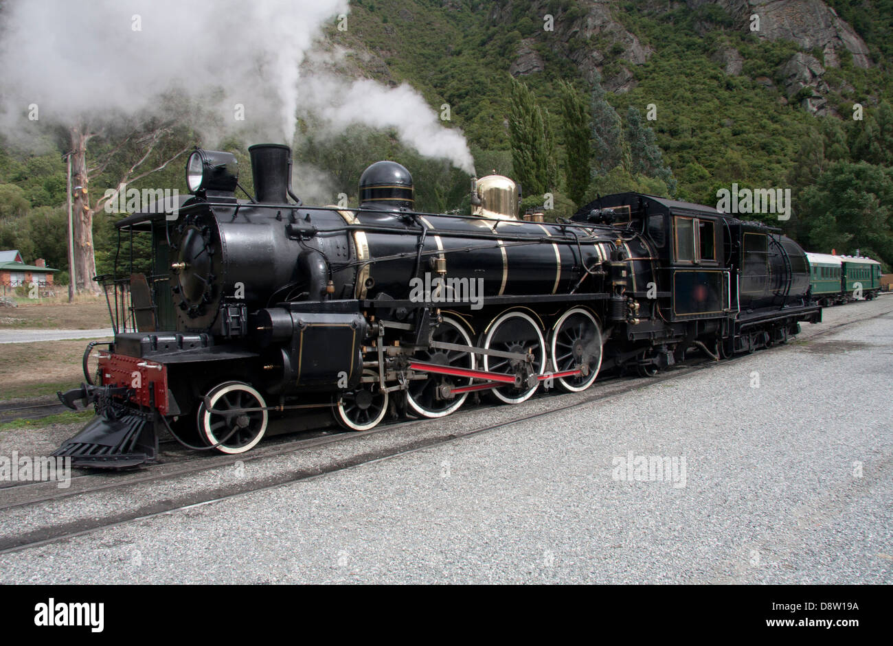 Steam locomotive slowly moving along train tracks Stock Photo - Alamy