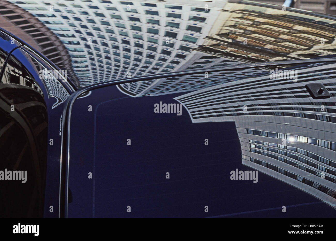 Refections of tall buildings in the rear window and roof of a black ...