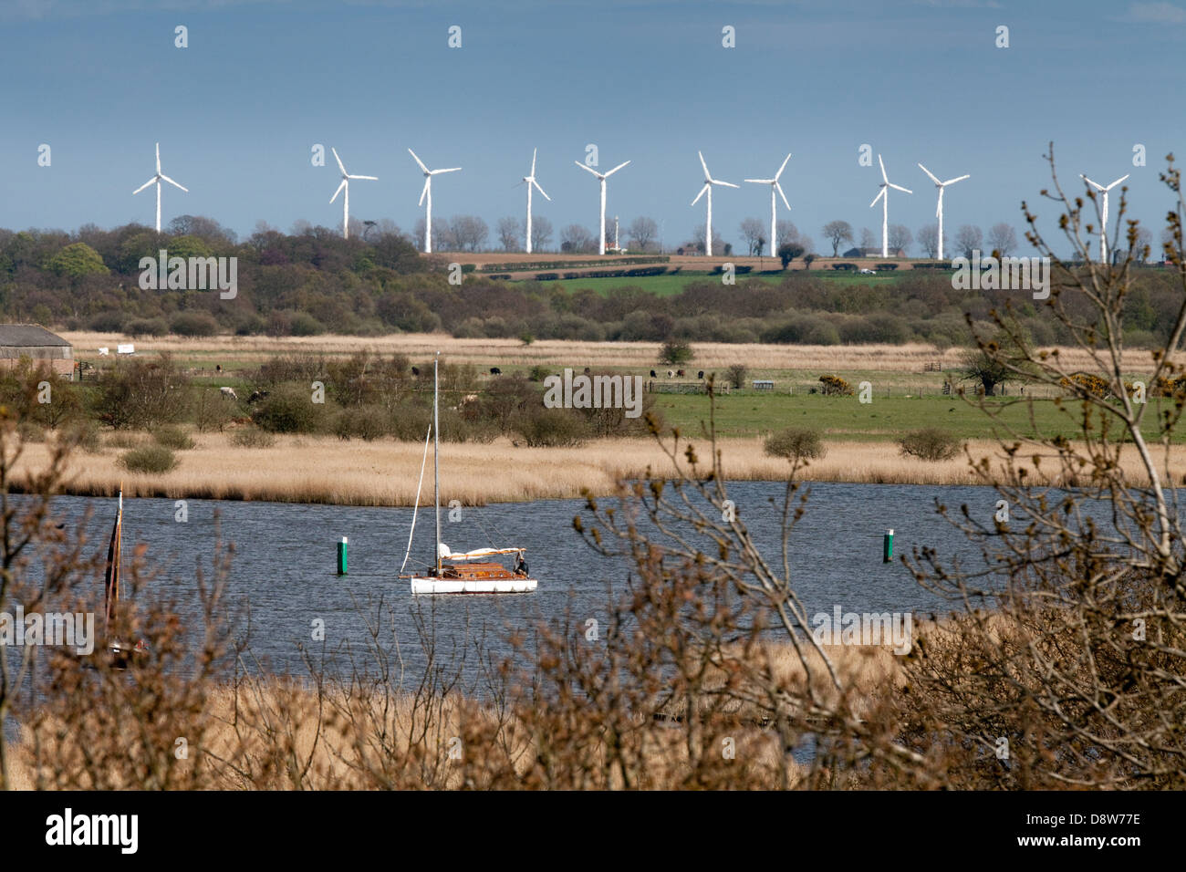 A sailboat on Hickling Broad with a wind farm behind, Norfolk Broads ...