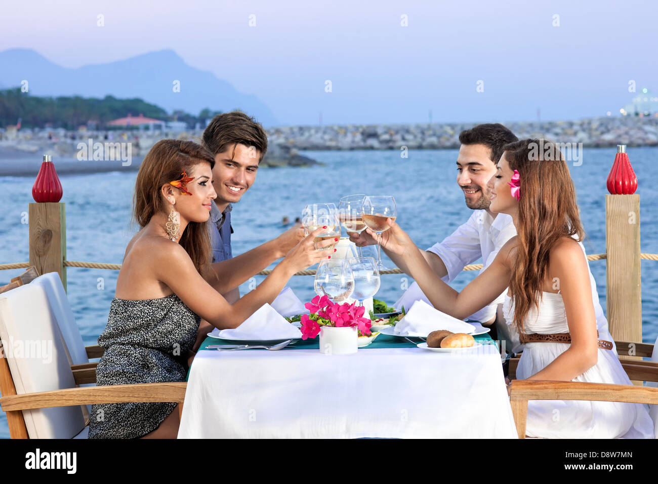 Friends celebrating at a seaside restaurant Stock Photo - Alamy