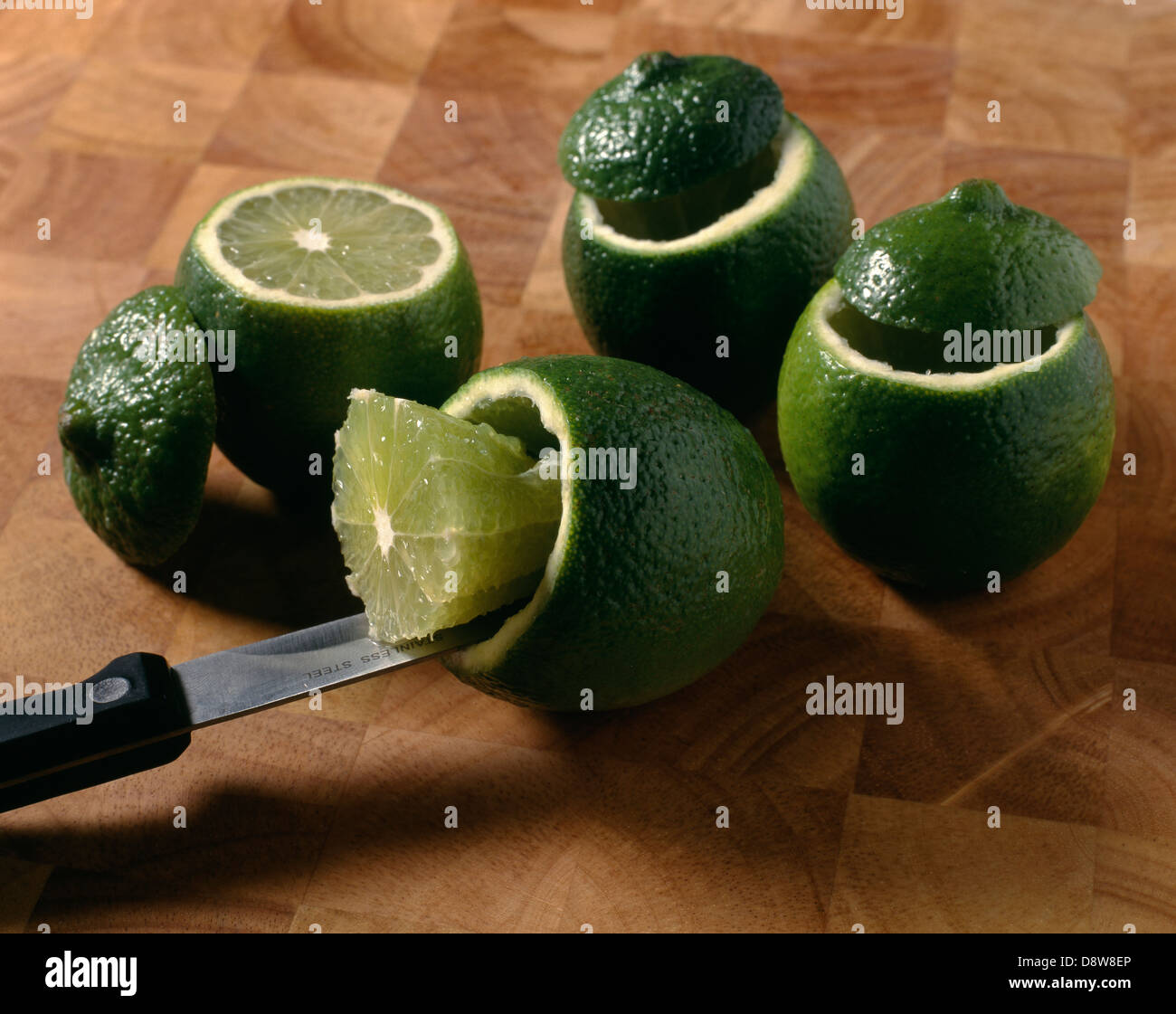 Scooping out the flesh of the limes with a knife Stock Photo - Alamy