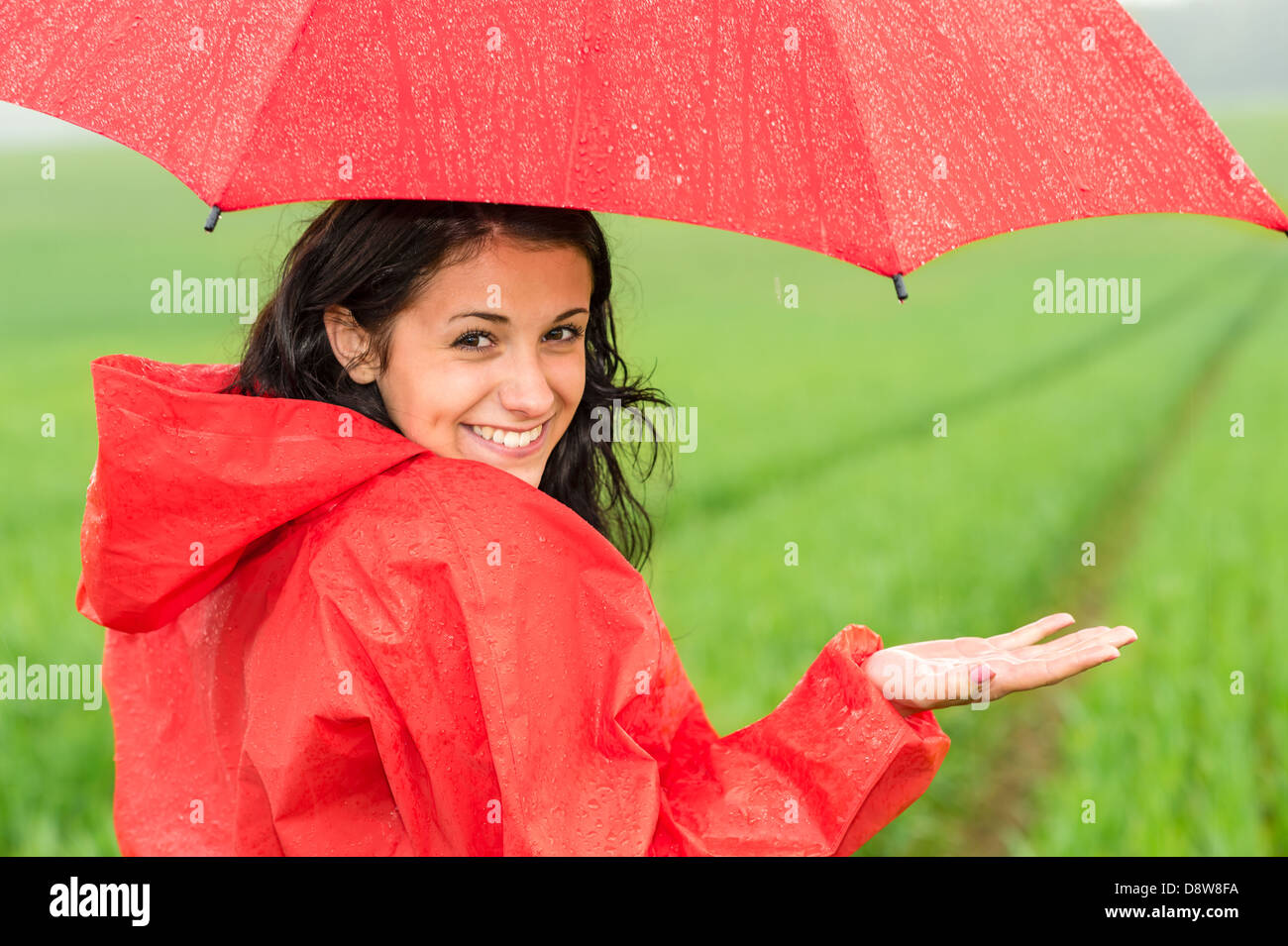 Lively teenager girl in the rain looking at camera Stock Photo - Alamy