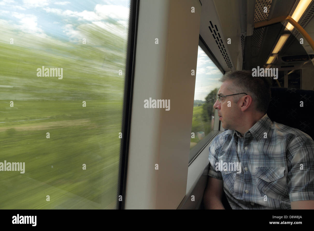 Man looking out window of moving train, Glasgow, Scotland, UK Stock ...