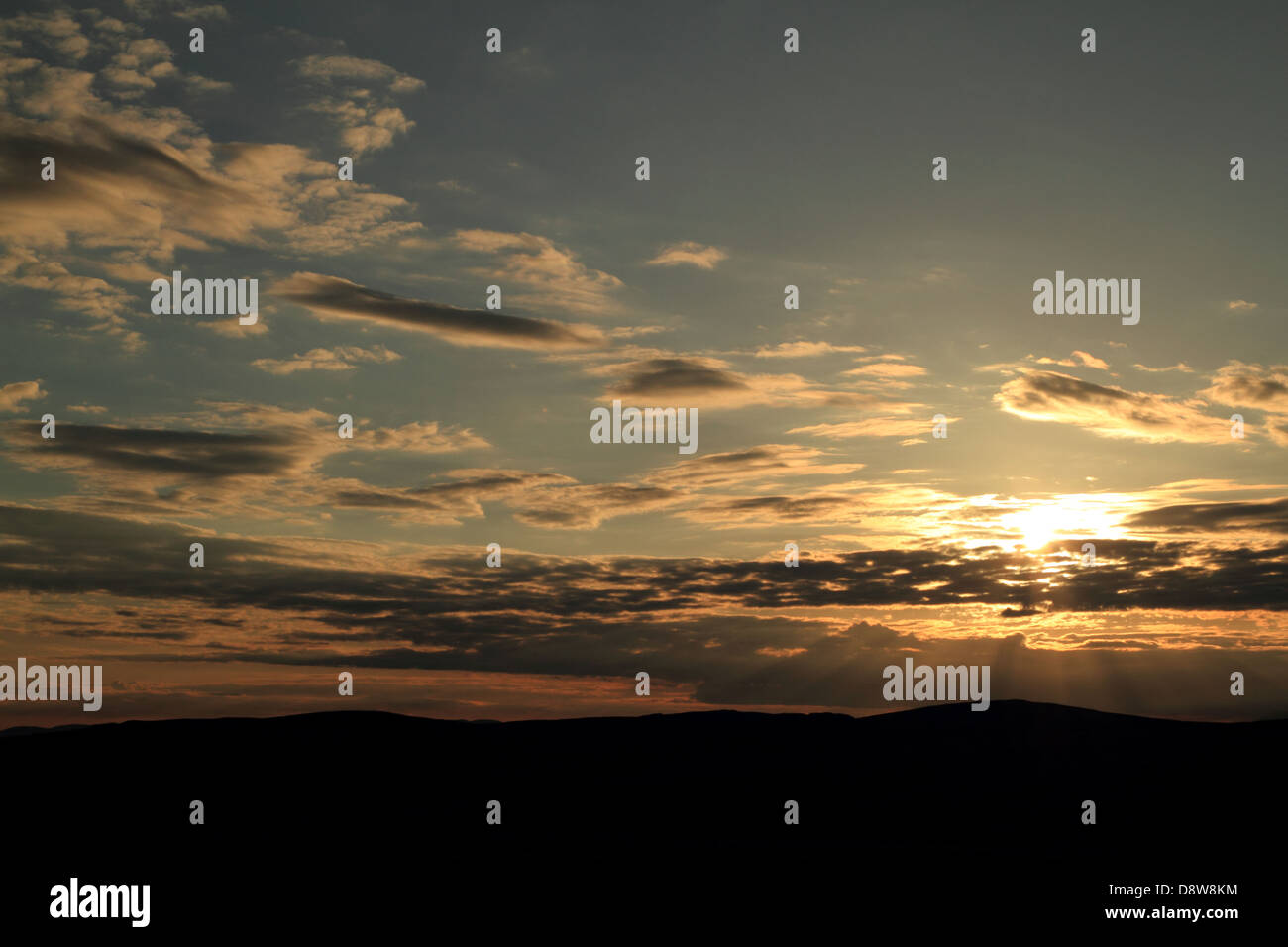 Golden light sunset, with sun rays coming through the clouds ...