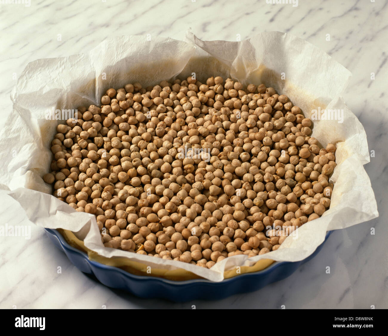 Placing wax paper and chickpeas in the mould to cook before garnishing ...