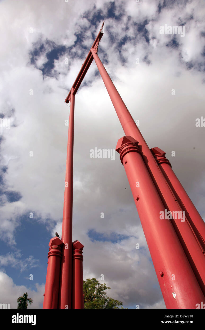 It's a photo of a Tall Buddhist gate near a temple. It's in red color ...