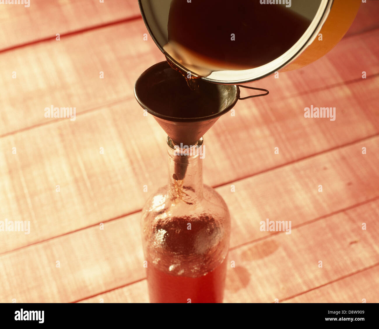 Pouring the strawberry syrup into a bottle Stock Photo - Alamy