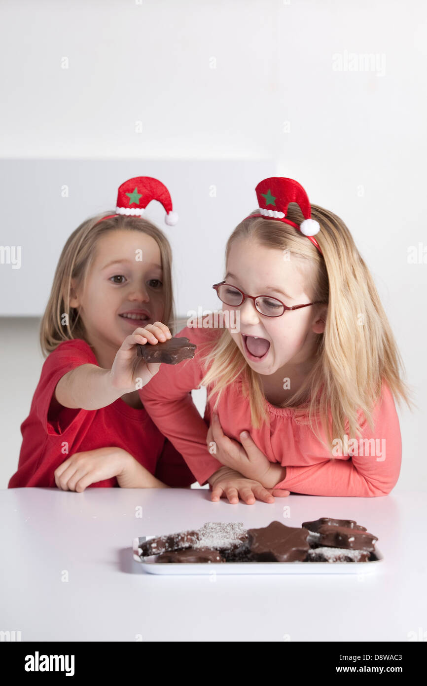 Young girls eating chocolate biscuits Stock Photo - Alamy