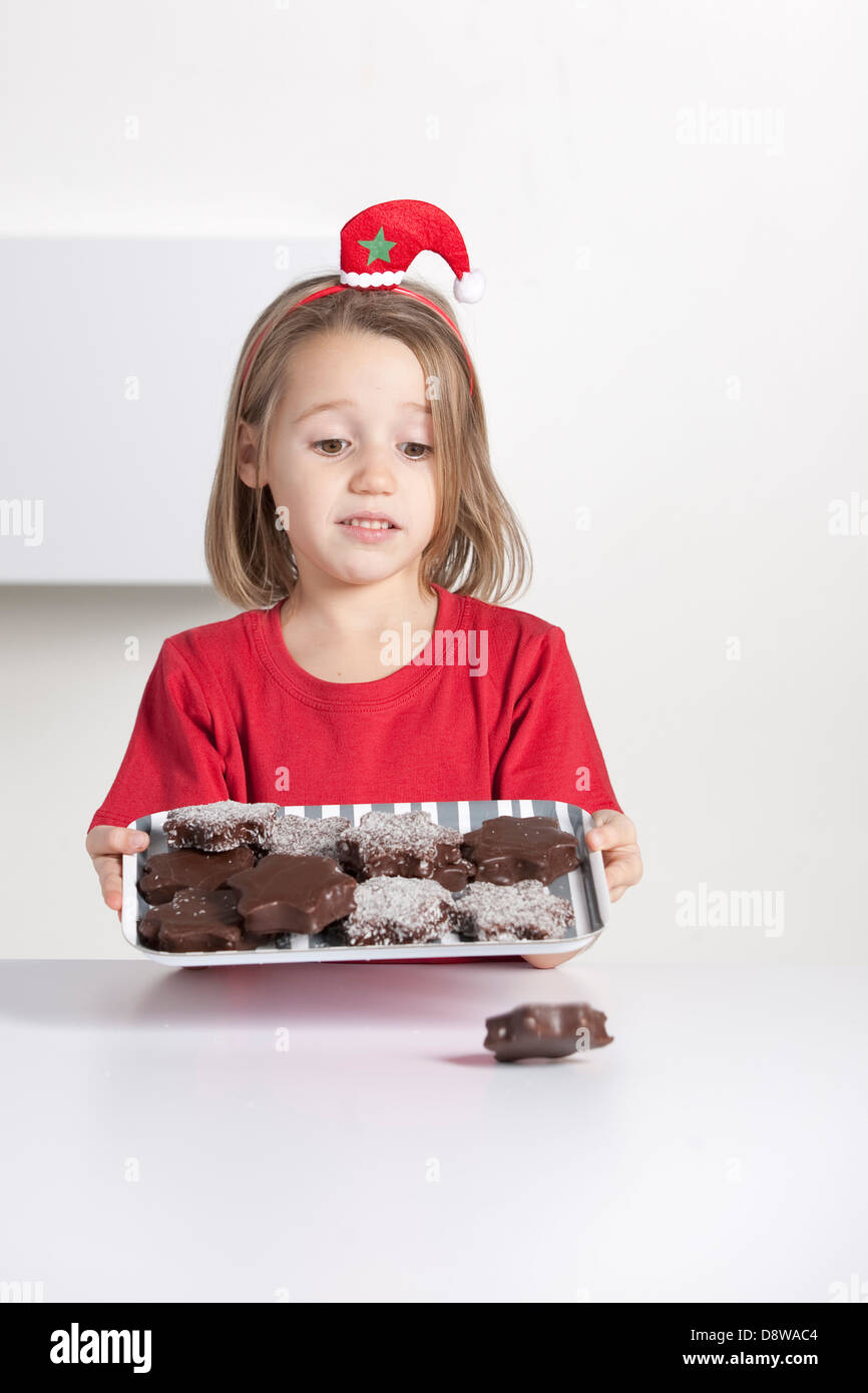 Young girl carrying a tray of chocolate biscuits Stock Photo - Alamy