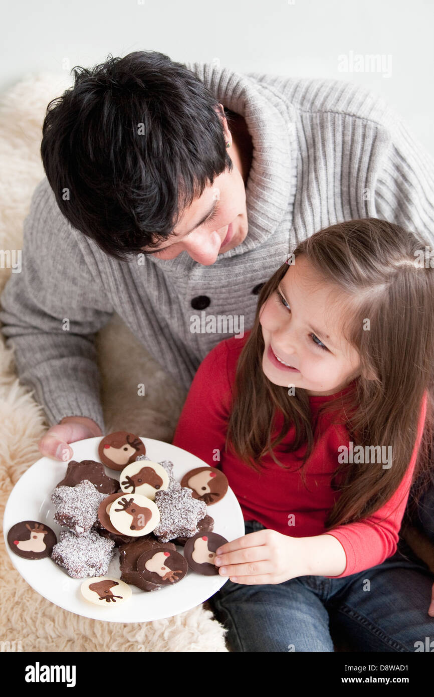Man offering a plate of chocolate cookies to a young girl Stock Photo ...