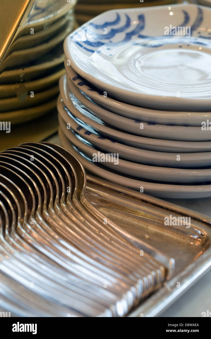 Stacked plates and lined up cutlery Stock Photo - Alamy