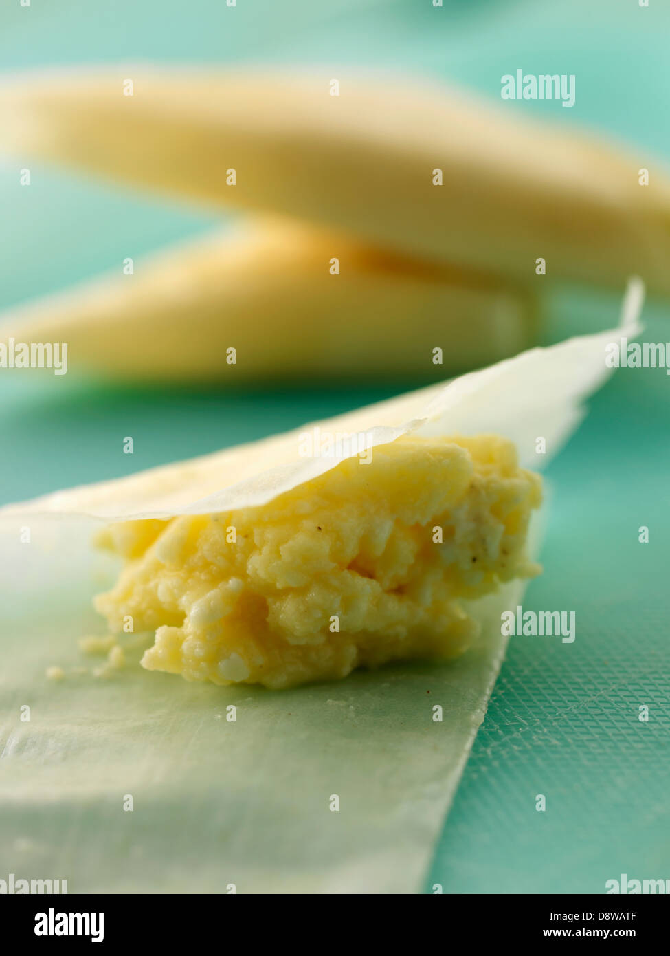 Folding the samossas with feta filling Stock Photo - Alamy