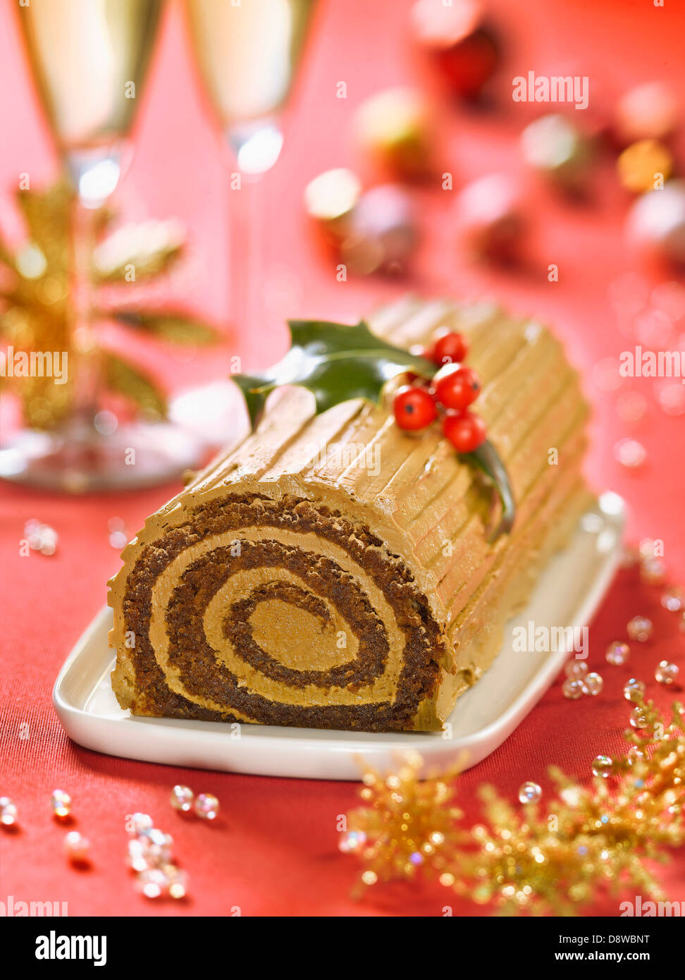 Christmas coffee log cake decorated with holly Stock Photo - Alamy