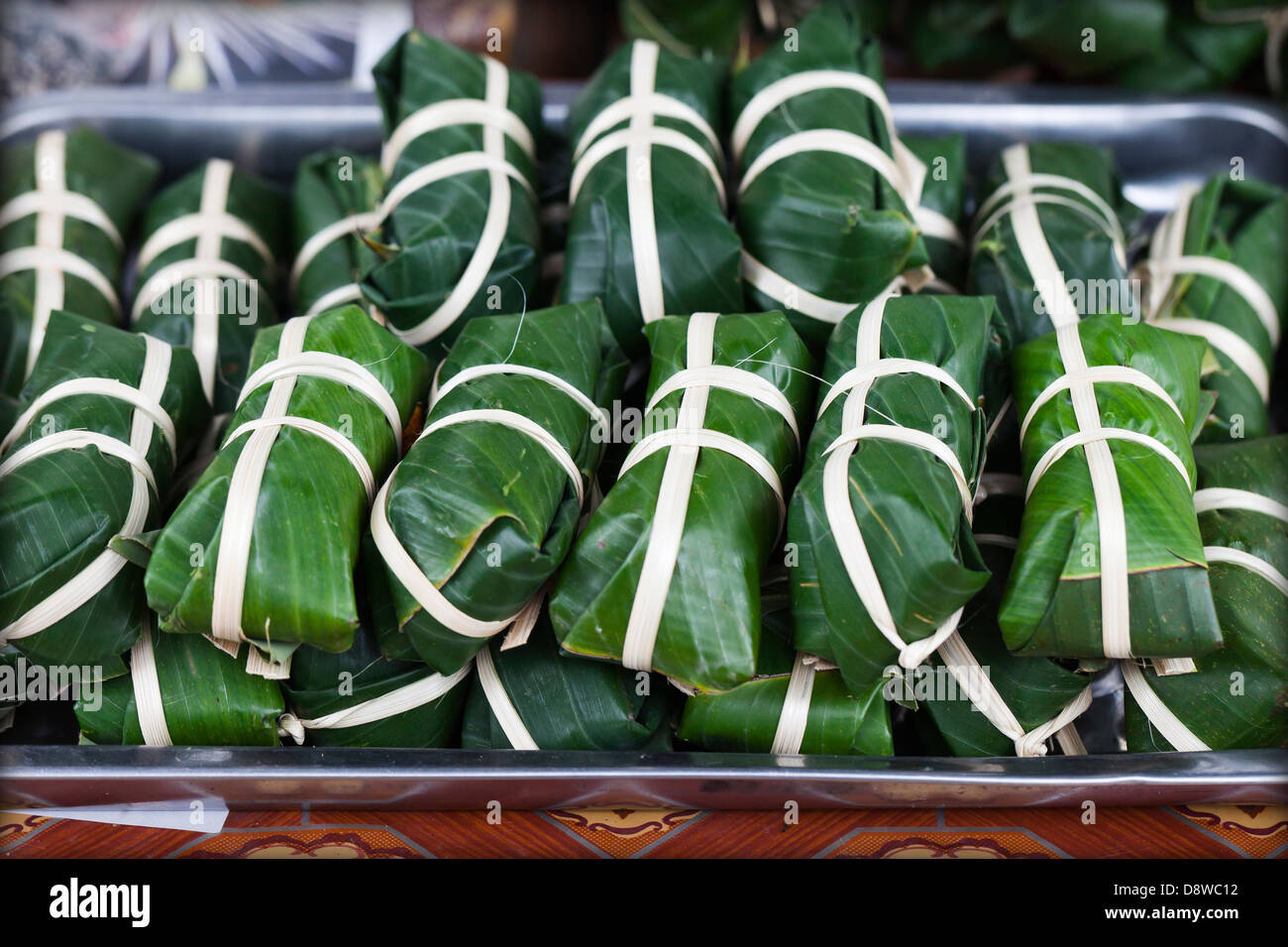 Sticky rice in banana leaves on a stall at the market in Luang Prabang ...