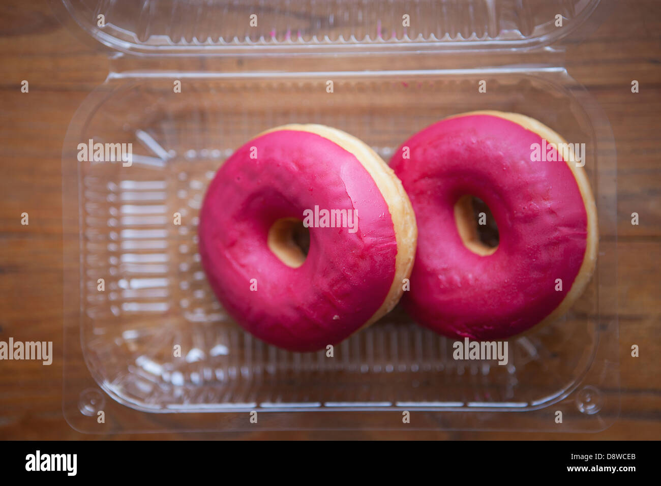 Raspberry donuts in a plastic container Stock Photo - Alamy