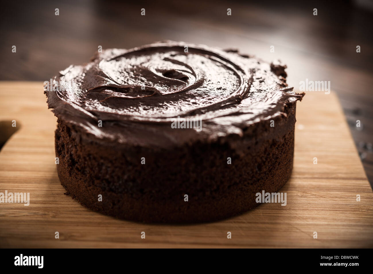 Whole Chocolate Cake back lit against a wood backdrop Stock Photo - Alamy