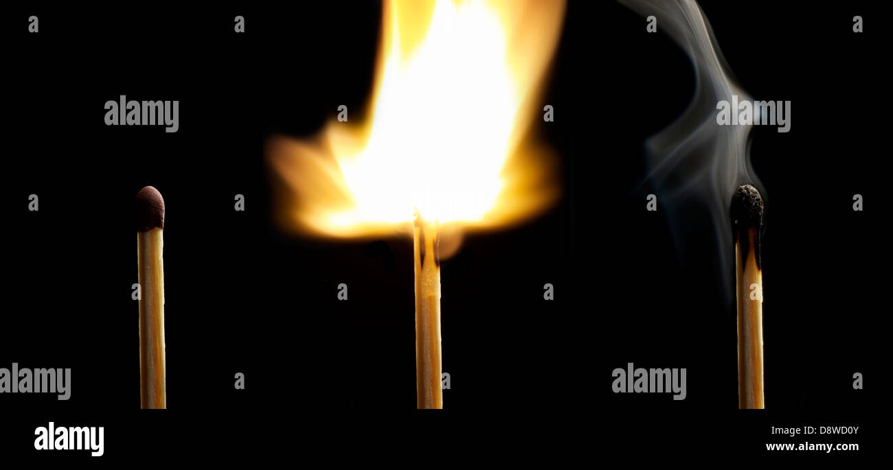 Matchstick burning on black background Stock Photo - Alamy