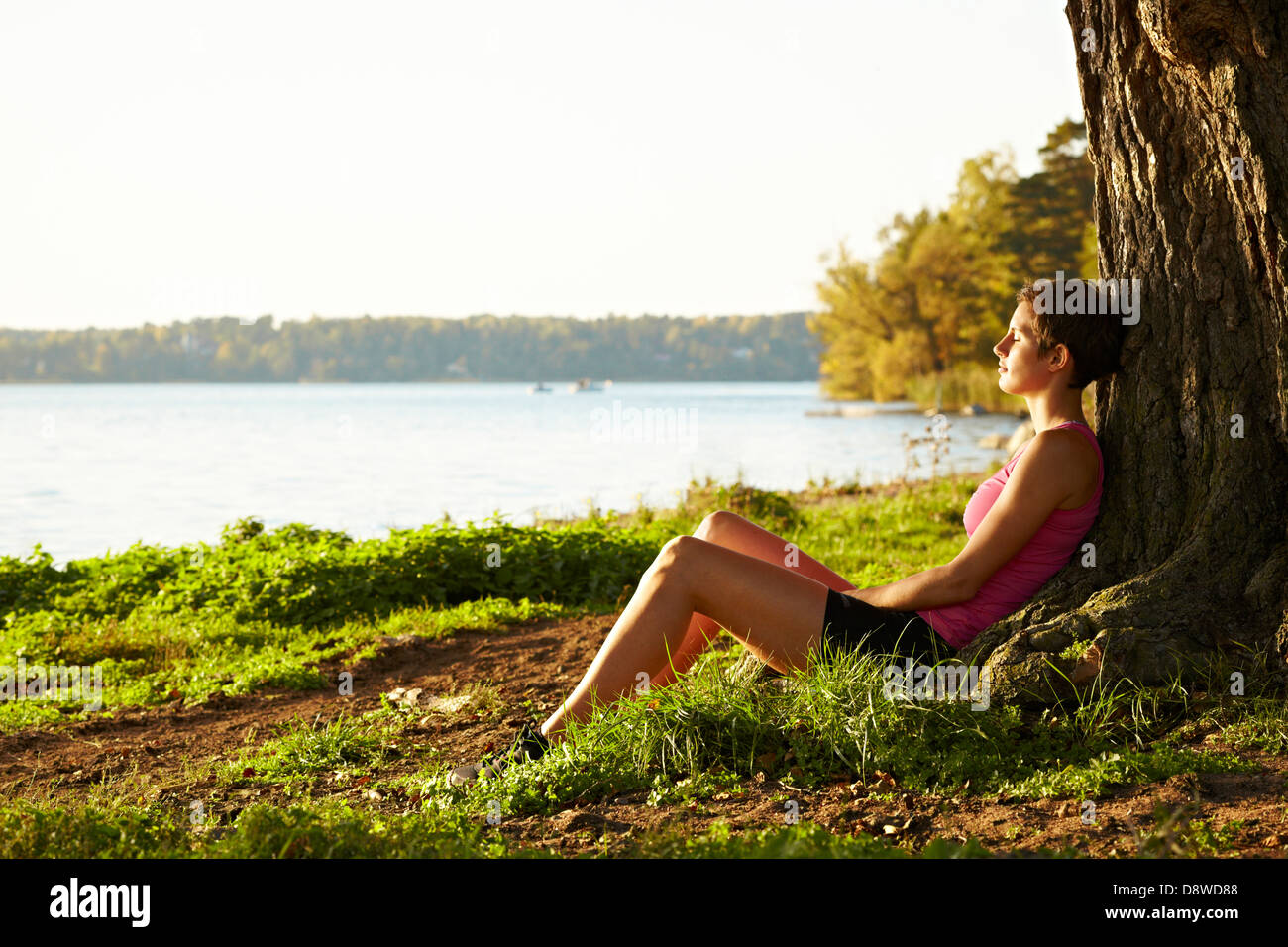 Young woman relaxing under tree Stock Photo - Alamy Young woman relaxing under tree Stock Photo - Alamy