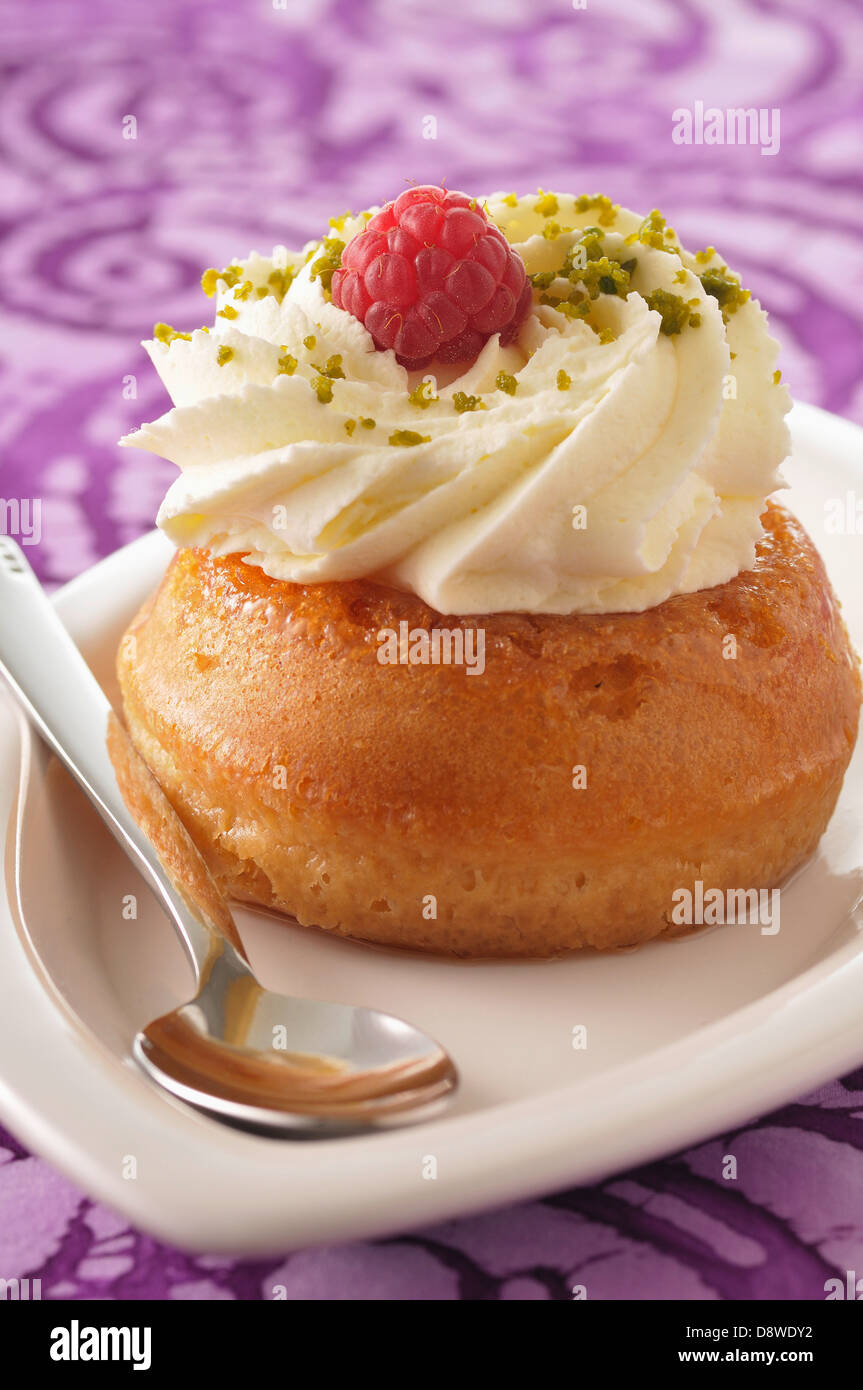 Rum Baba with raspberry and crushed pistachios Stock Photo - Alamy
