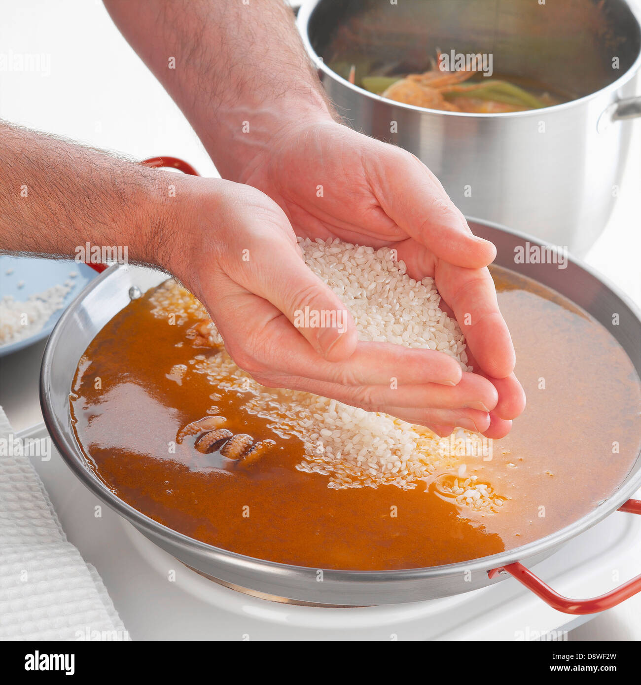 Gently adding the rice to the broth Stock Photo - Alamy