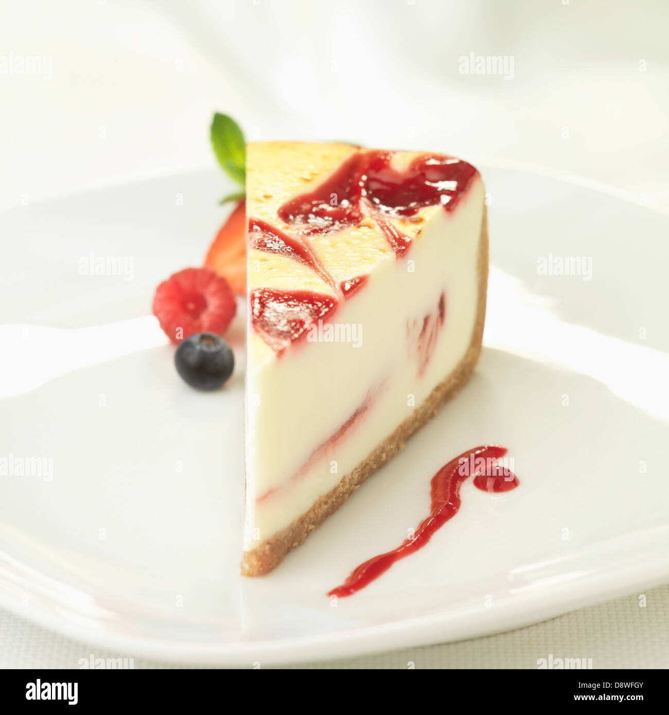 Slice of cheesecake with summer fruit puree Stock Photo - Alamy