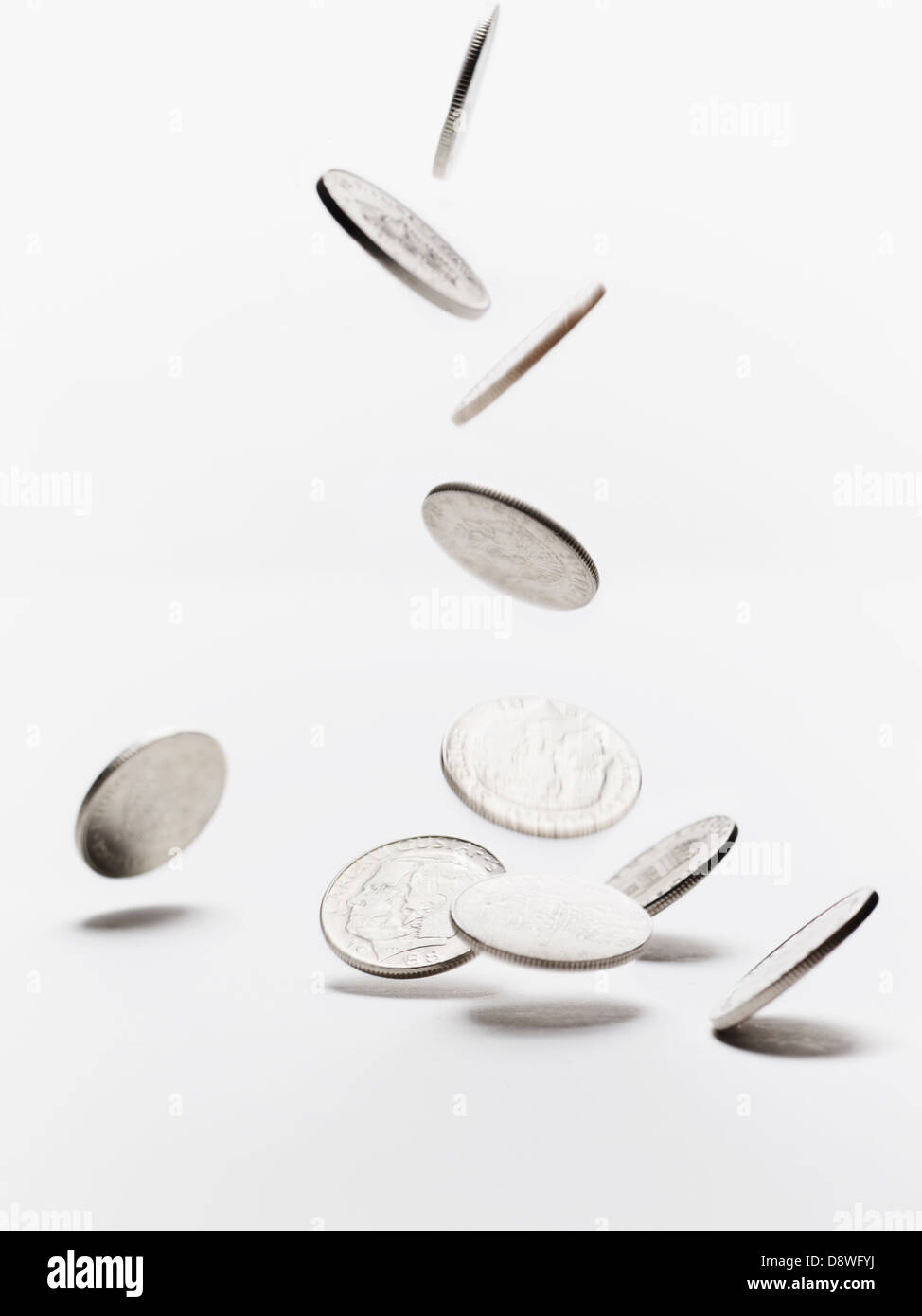 Close up of falling coins on white background Stock Photo - Alamy