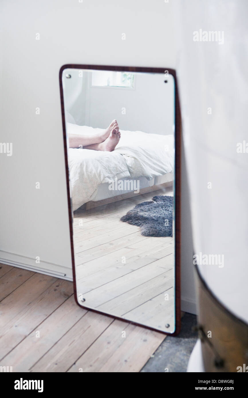 Human feet reflecting in bedroom mirror Stock Photo - Alamy