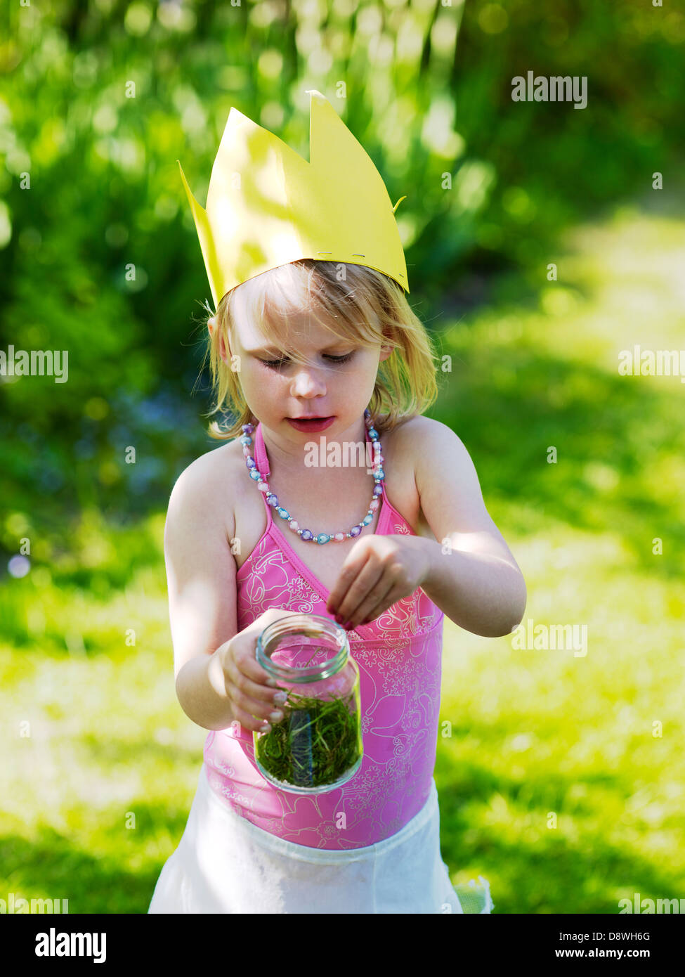 Girl wearing paper crown holding jar Stock Photo - Alamy