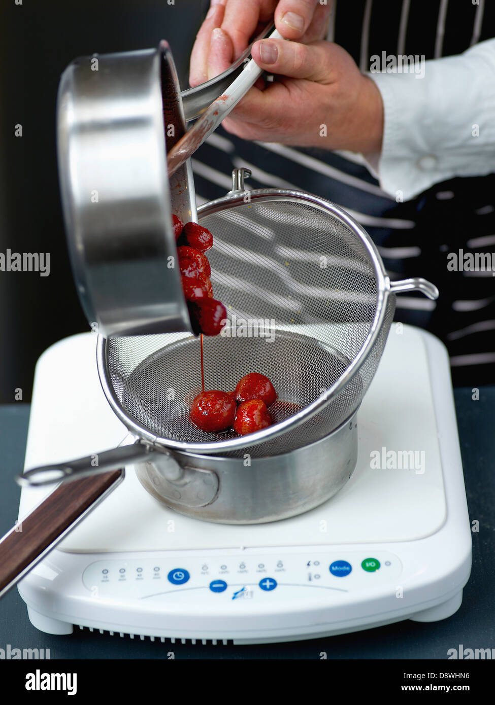 Sieving the strawberries to collect the juice Stock Photo - Alamy