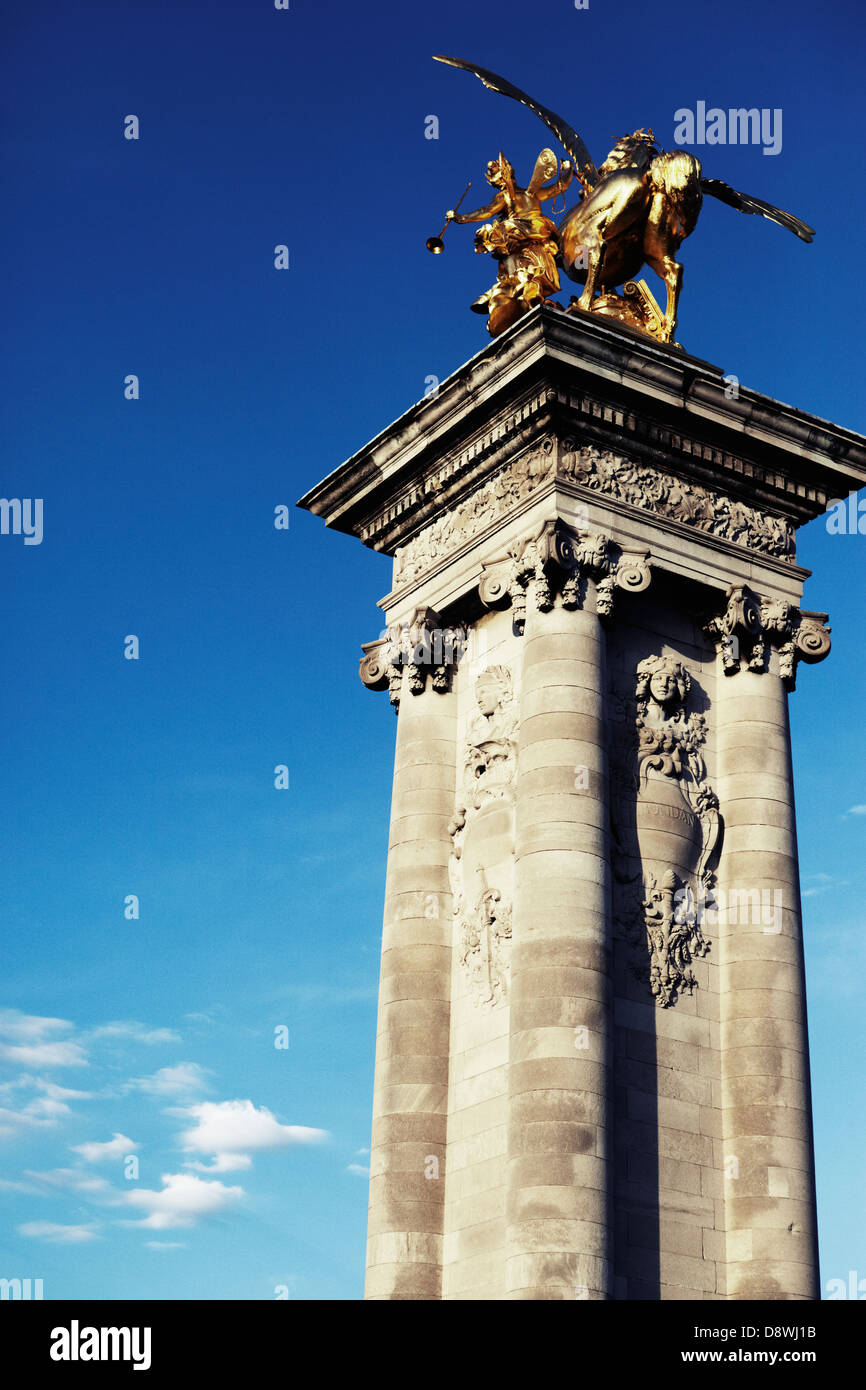 Low angle view of golden statue on pillar Stock Photo - Alamy