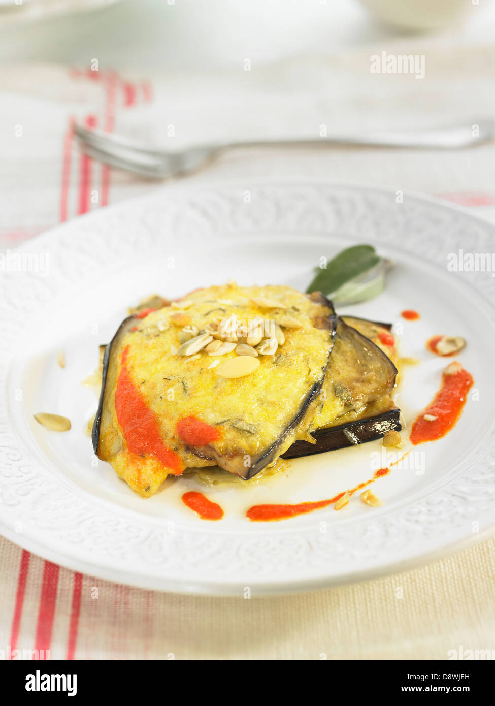 Eggplants with emmental and seeds,red pepper sauce Stock Photo - Alamy