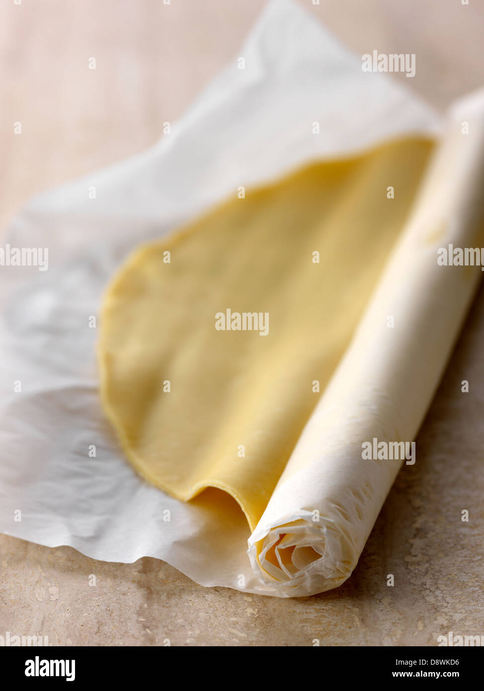 Unrolling uncooked pie dough in wax paper Stock Photo - Alamy