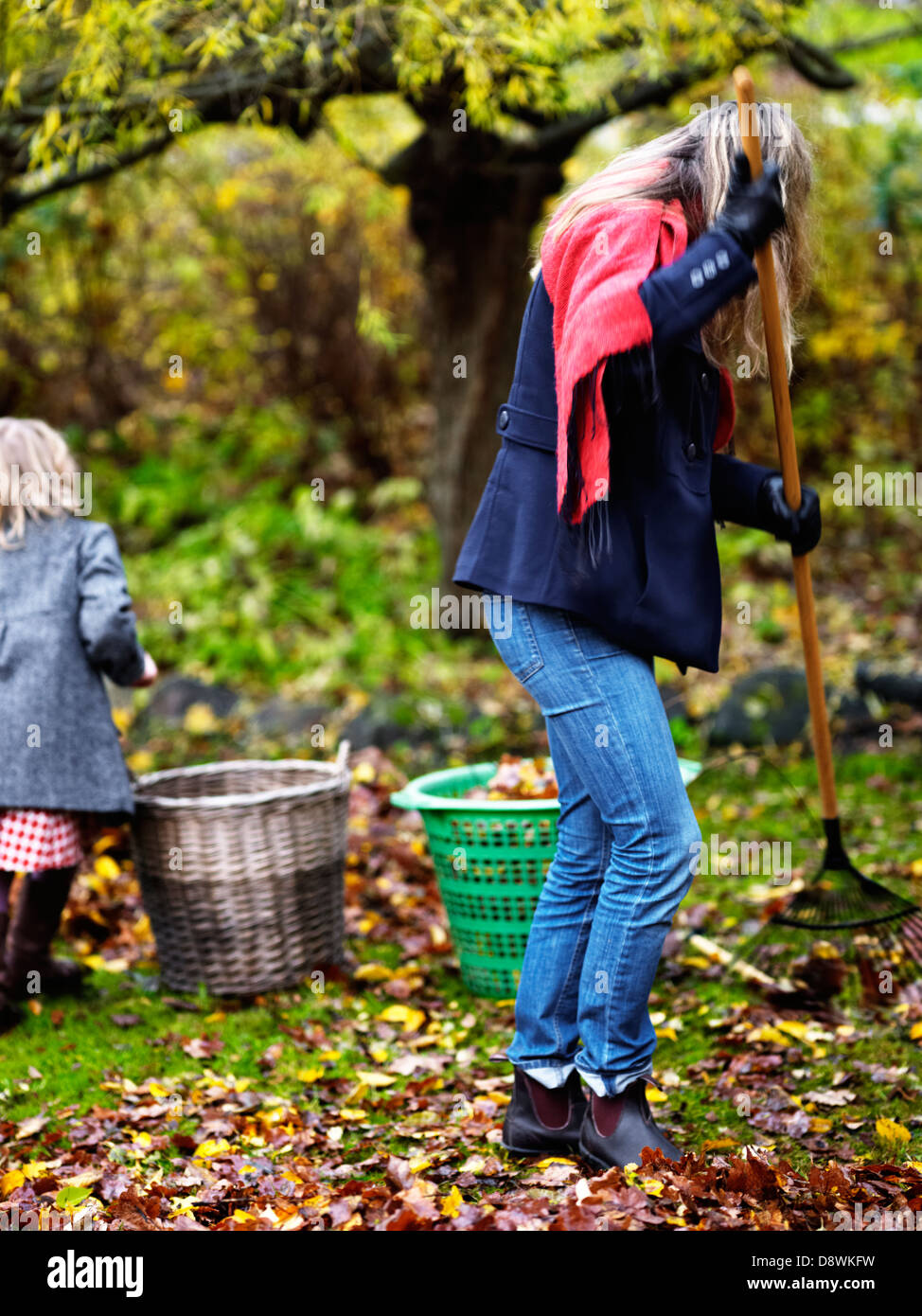 Woman and girl raking leaves Stock Photo - Alamy