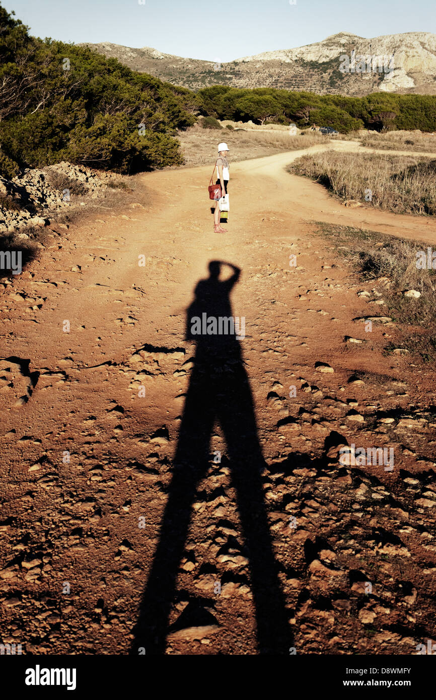 Shadow of man photographing hiker on dirt road Stock Photo - Alamy