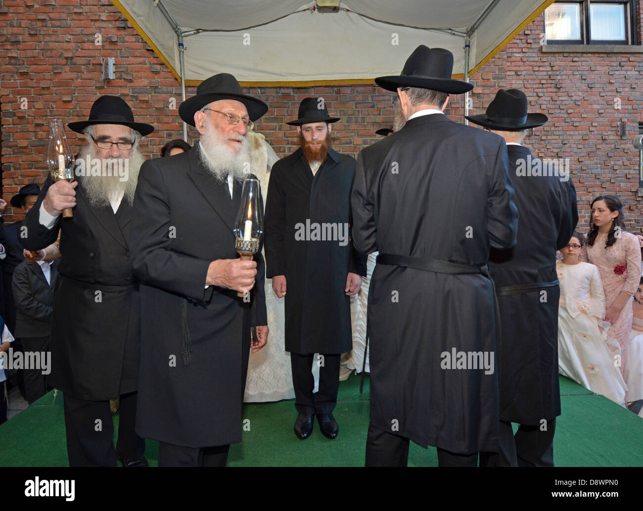 A orthodox religious Jewish bride and groom under a canopy at their ...