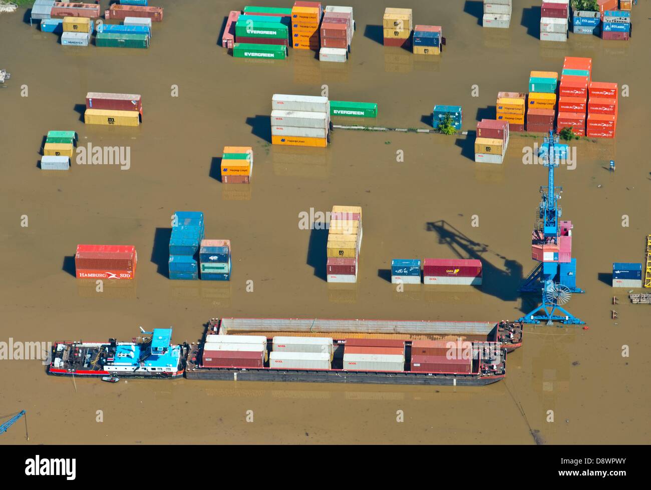 Containers and warehouses stand submerged in the floodwater of the ...