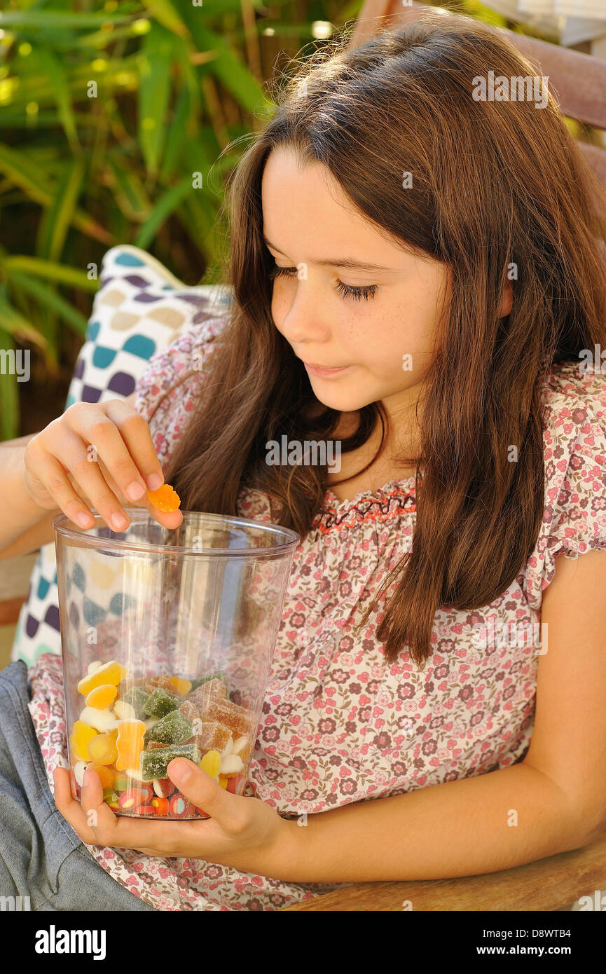 Young girl eating candies Stock Photo - Alamy