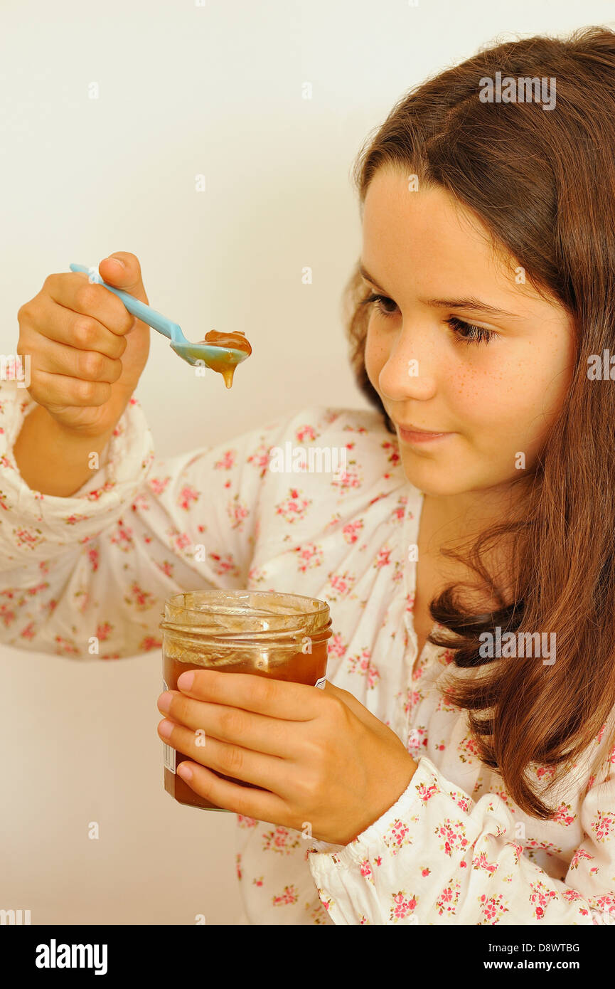 Young girl playing with a jar of jam Stock Photo - Alamy