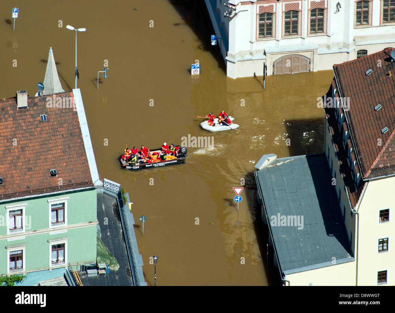 Helpers patrol in rubber dinghis through the flooded parts of the ...