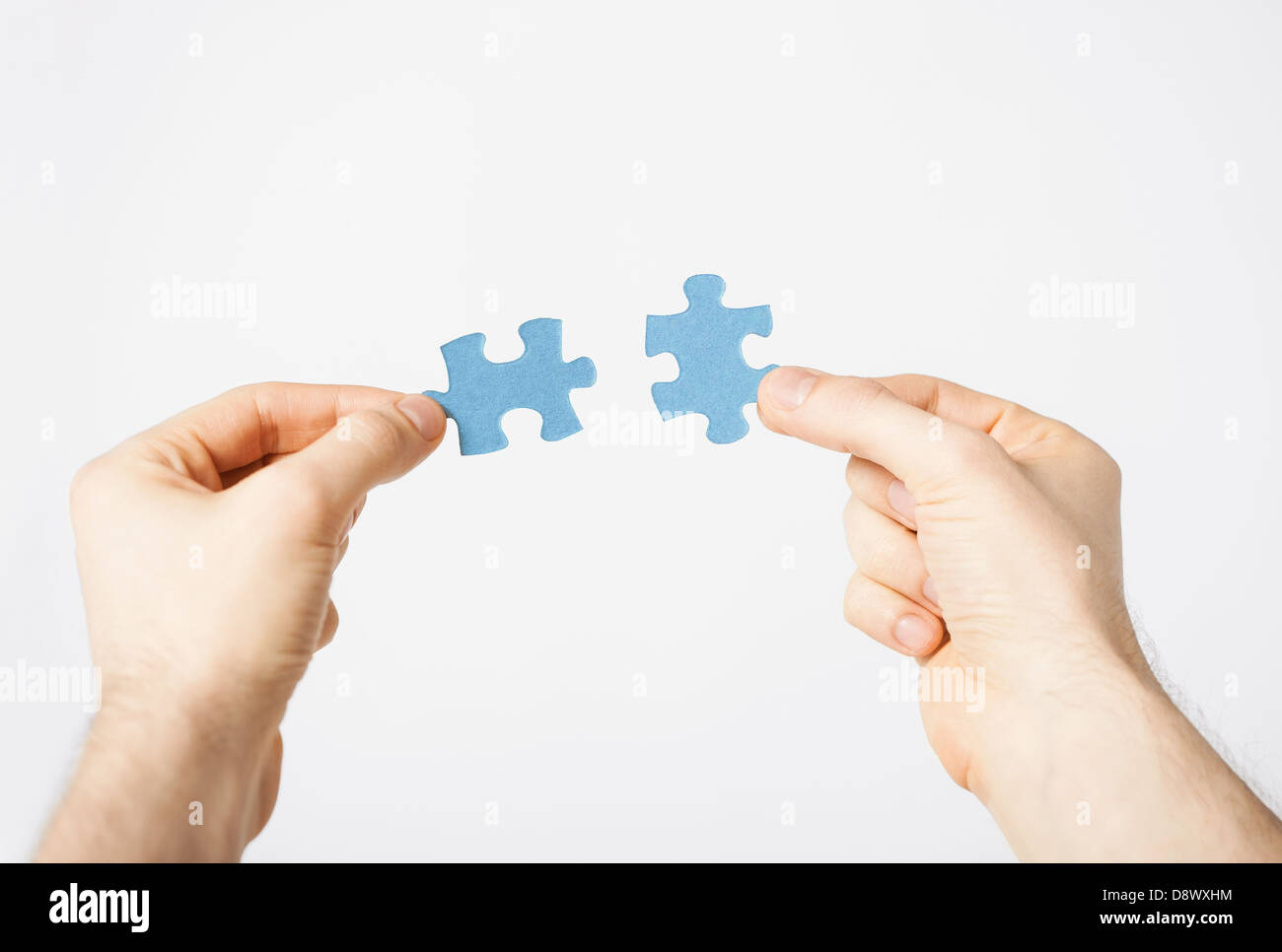 two hands trying to connect puzzle pieces Stock Photo - Alamy